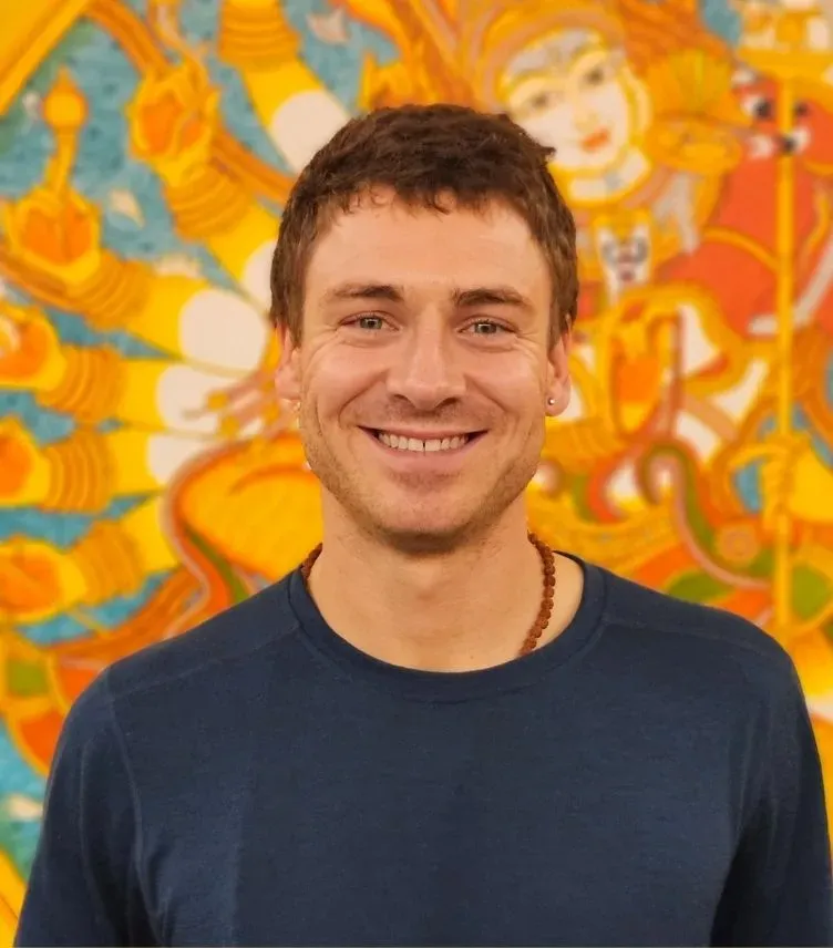 Portrait of a smiling guest standing in front of a bright traditional ...